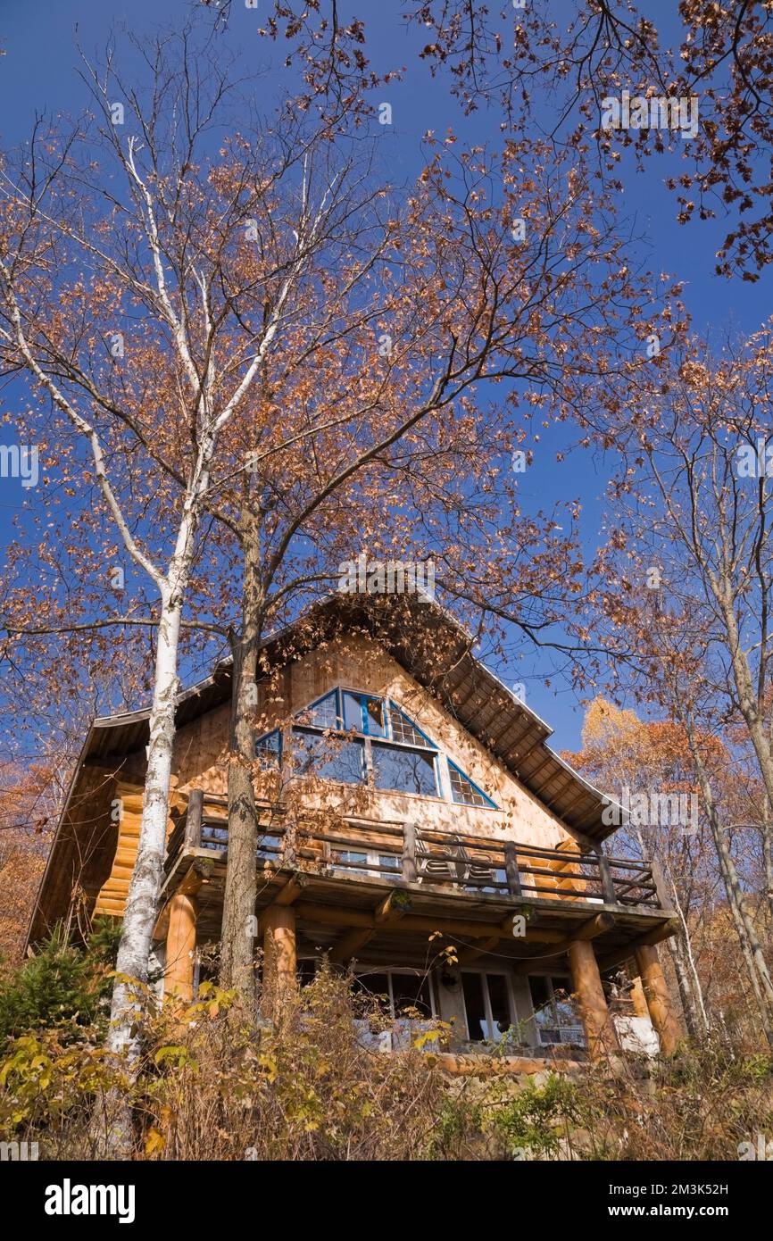 A-frame style log cabin framed through trees in autumn Stock Photo - Alamy
