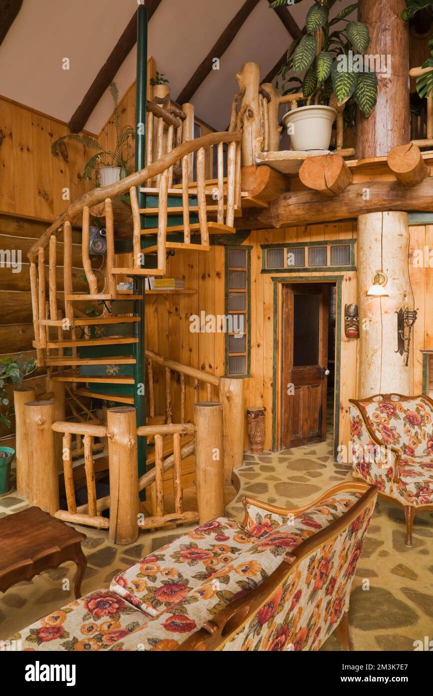 Spiraling staircase in living room inside rustic log cabin Stock Photo ...