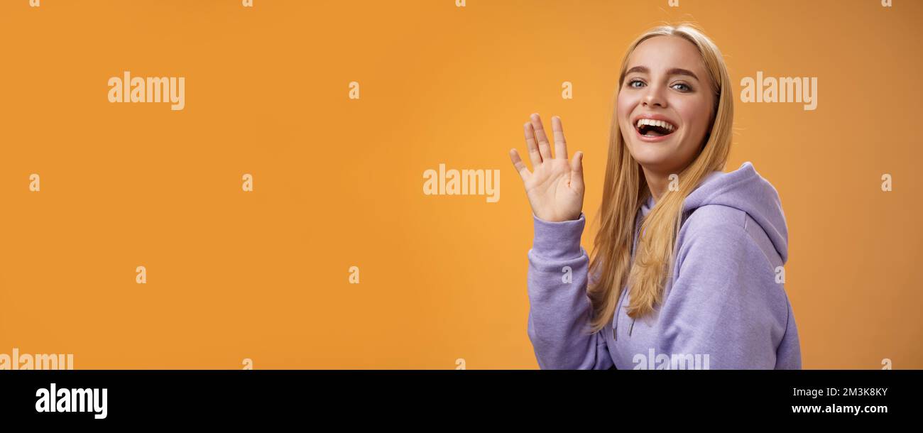 Waist-up friendly lucky cute blond girl waving palm happily smiling ...