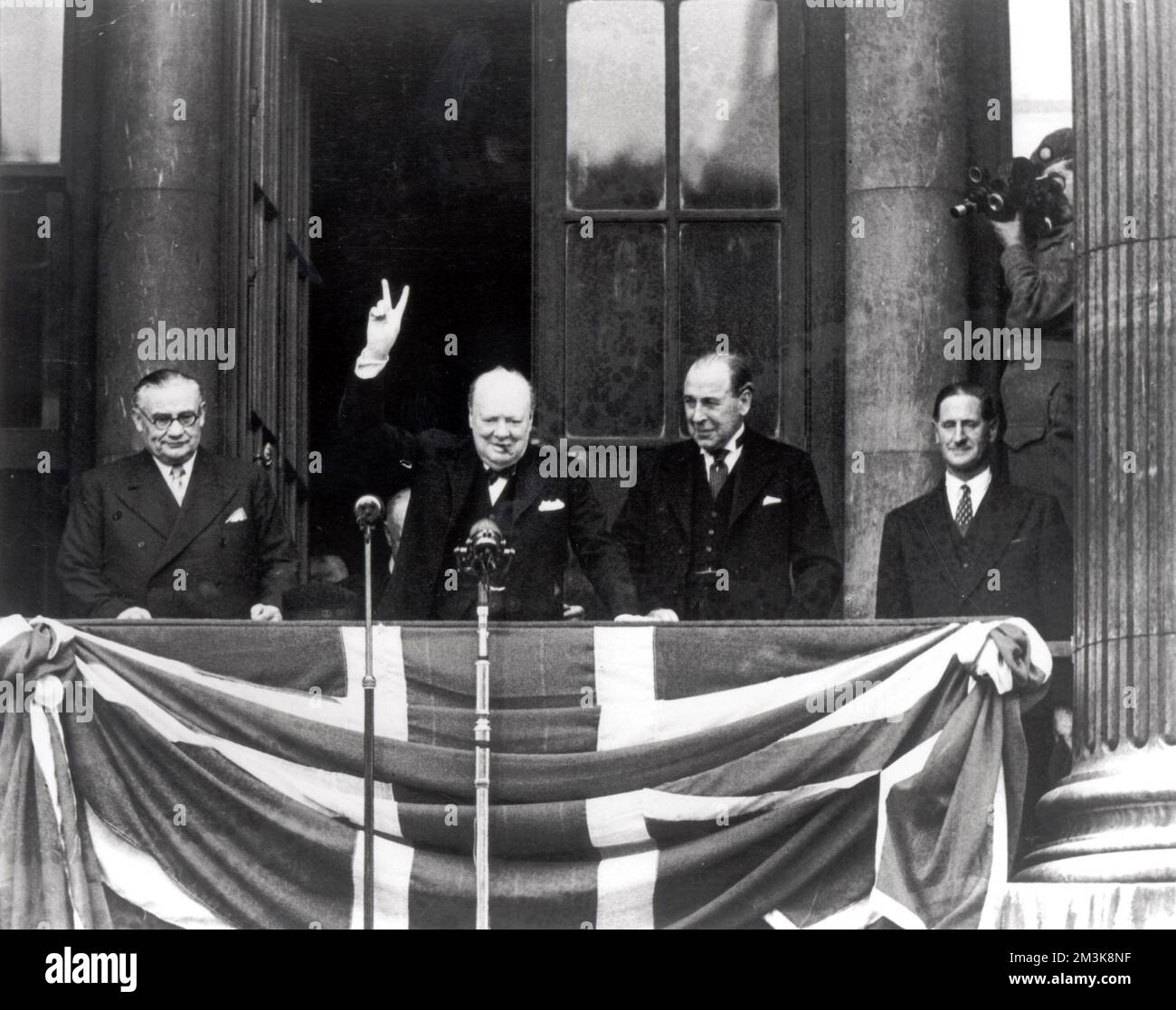 The photograph shows Winston Churchill and Ernest Bevin on the balcony ...