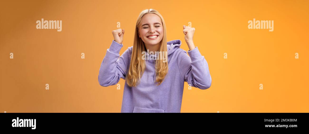 Triumphing celebrating positive fair-haired young female winner raise ...