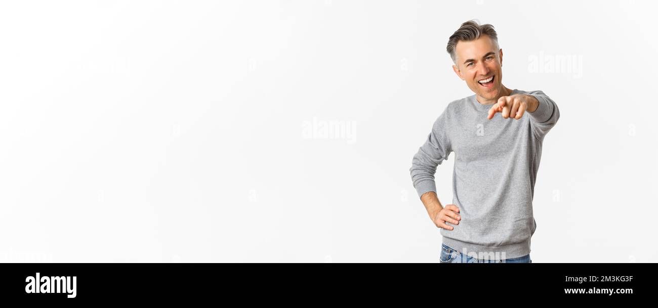Image of handsome middle-aged man smiling and pointing finger at camera ...