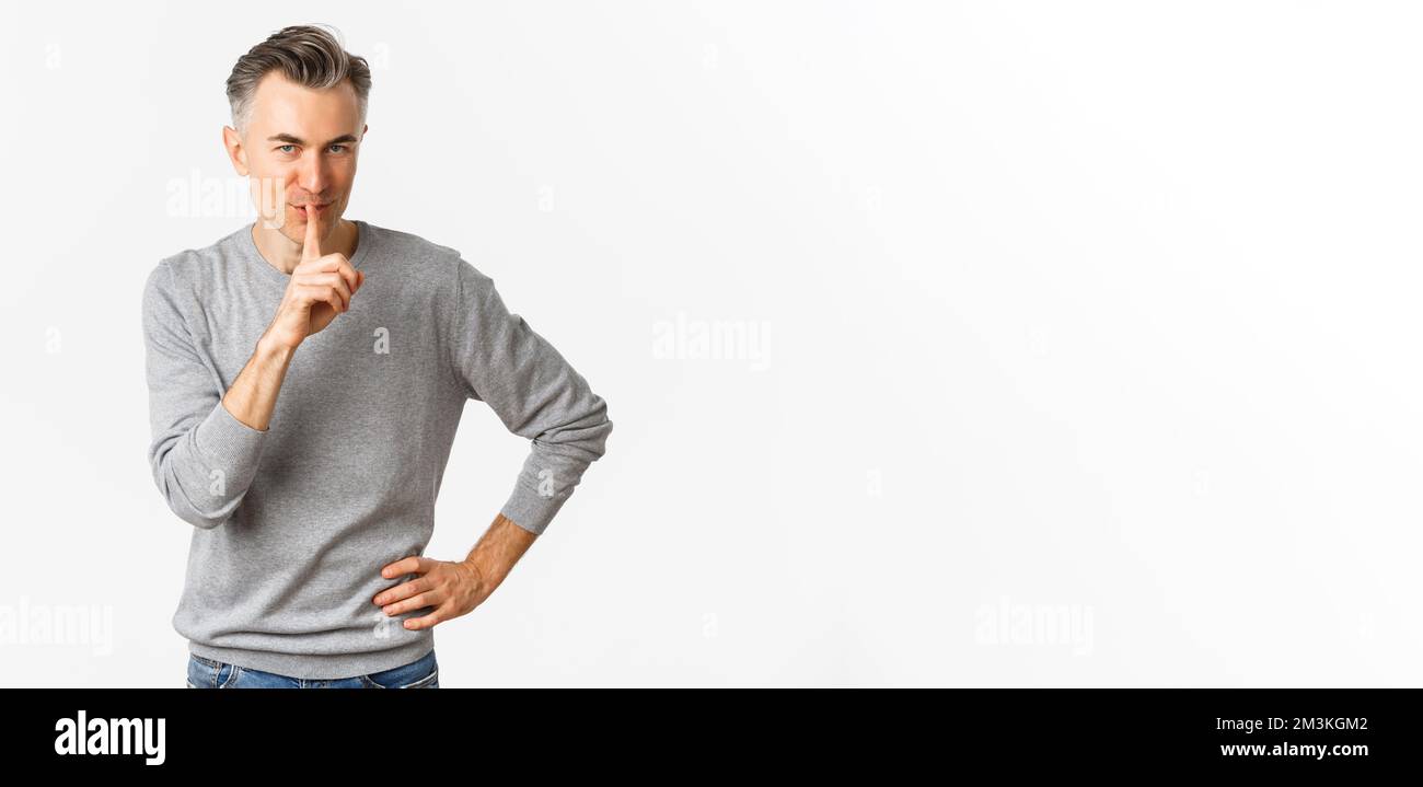 Portrait of cunning handsome man with gray hair, hushing and smiling ...
