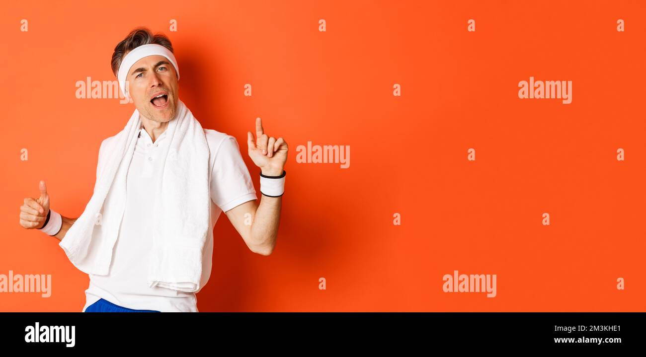 Image of happy and carefree middle-aged fitness guy, dancing after ...