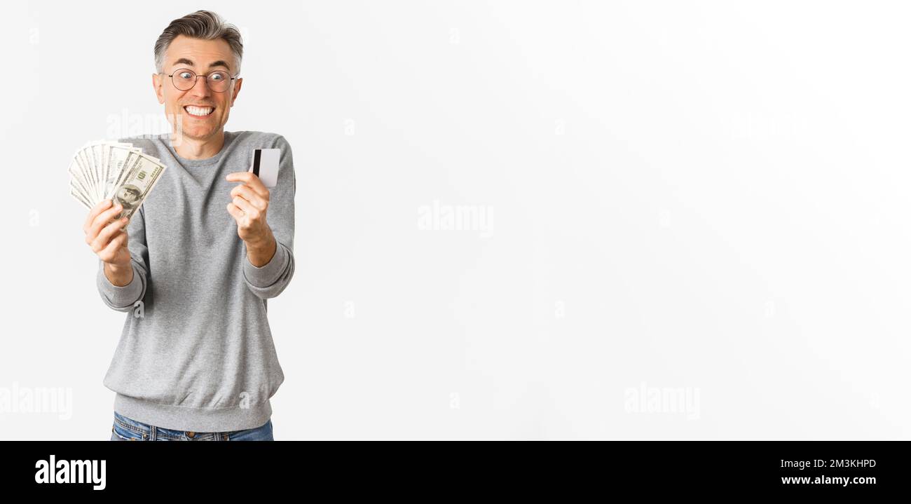 Portrait of excited and happy middle-aged man, looking amazed at credit ...