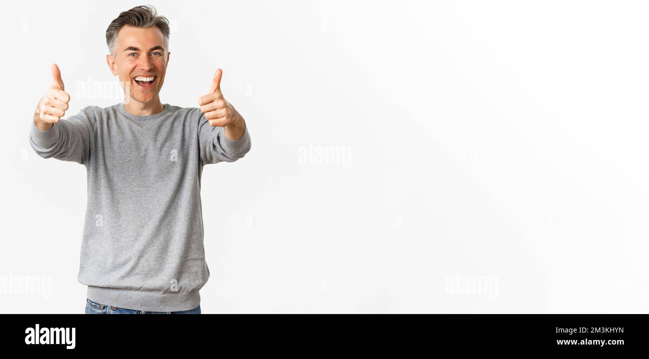 Portrait of cheerful middle-aged man praising good work, standing over ...
