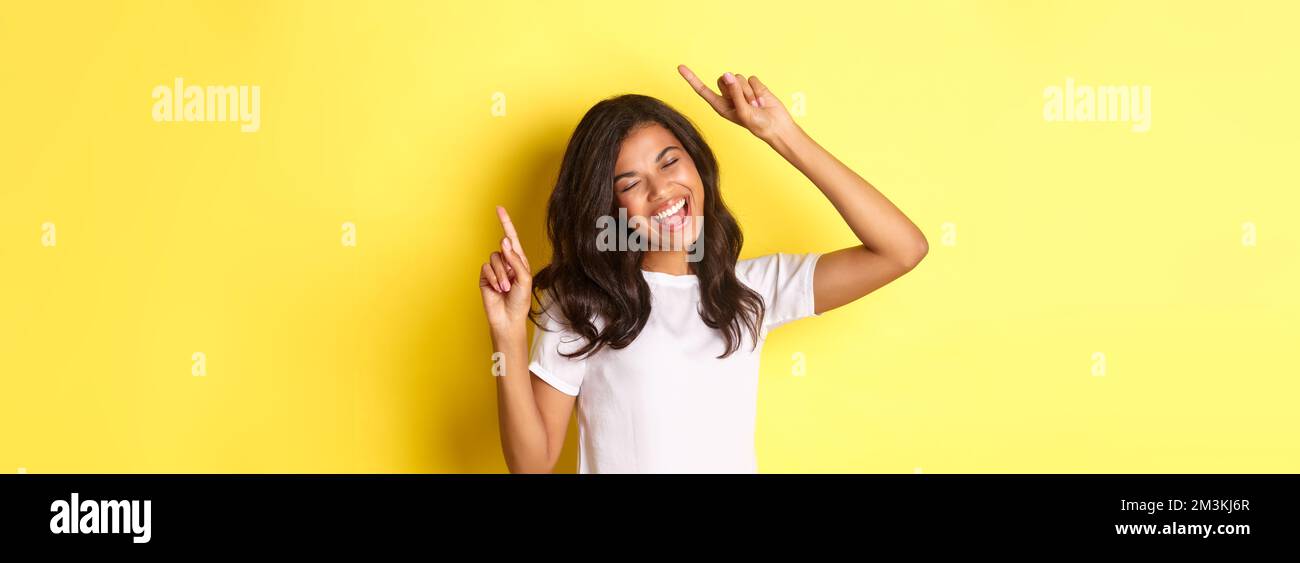Portrait of cheerful african-american girl, dancing and singing ...