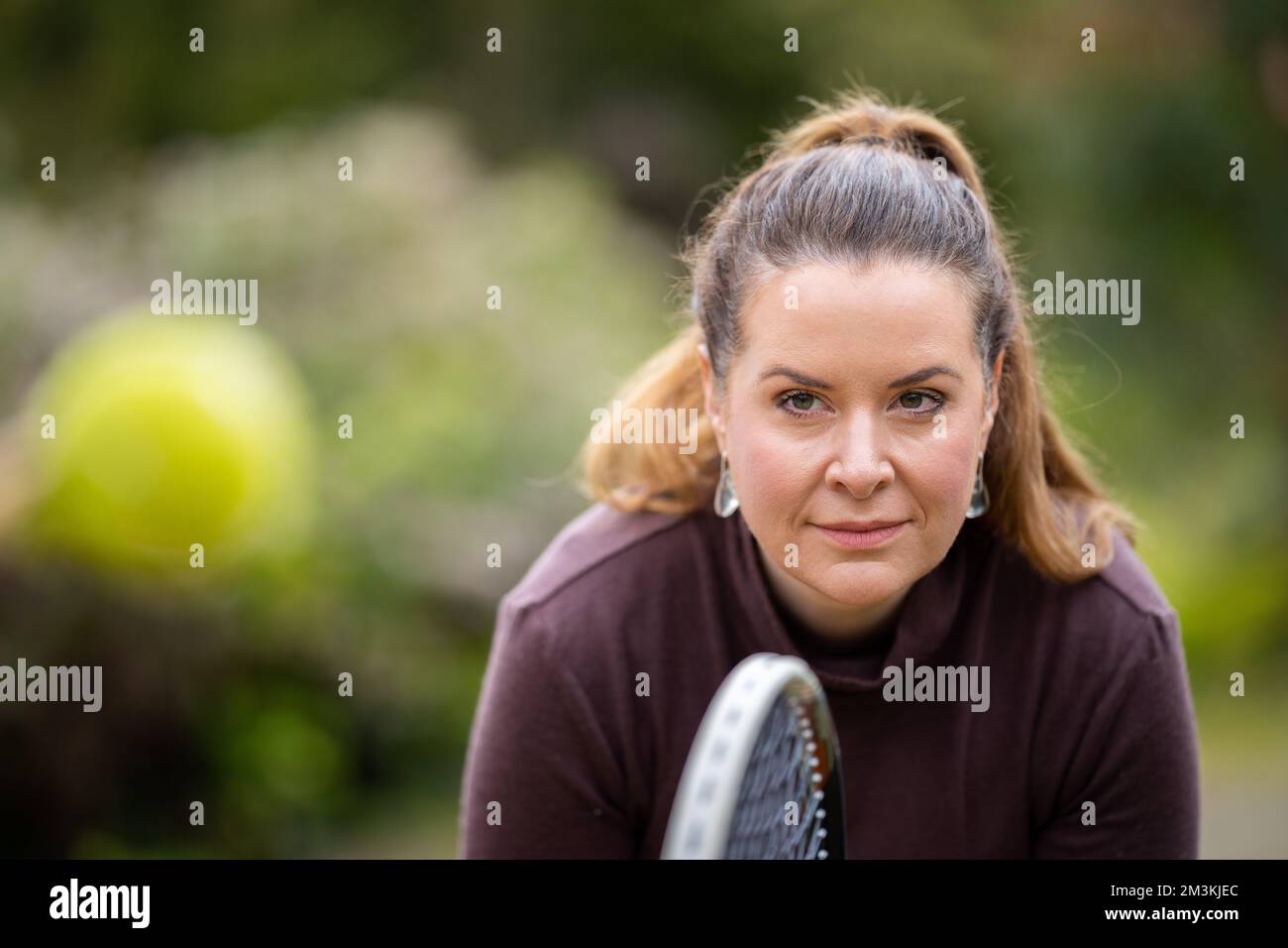 female tennis player practicing forehands and hitting tennis balls on a ...