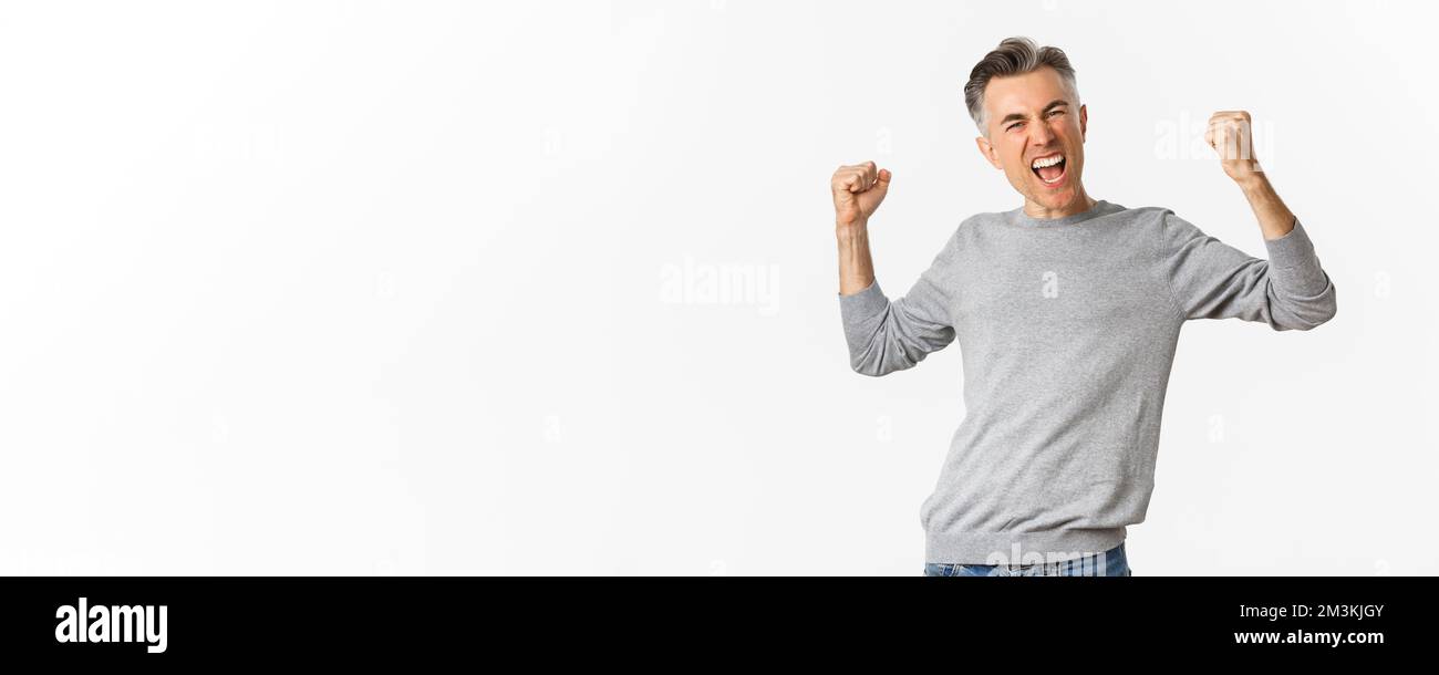 Image of successful middle-aged man triumphing, shouting for joy ...