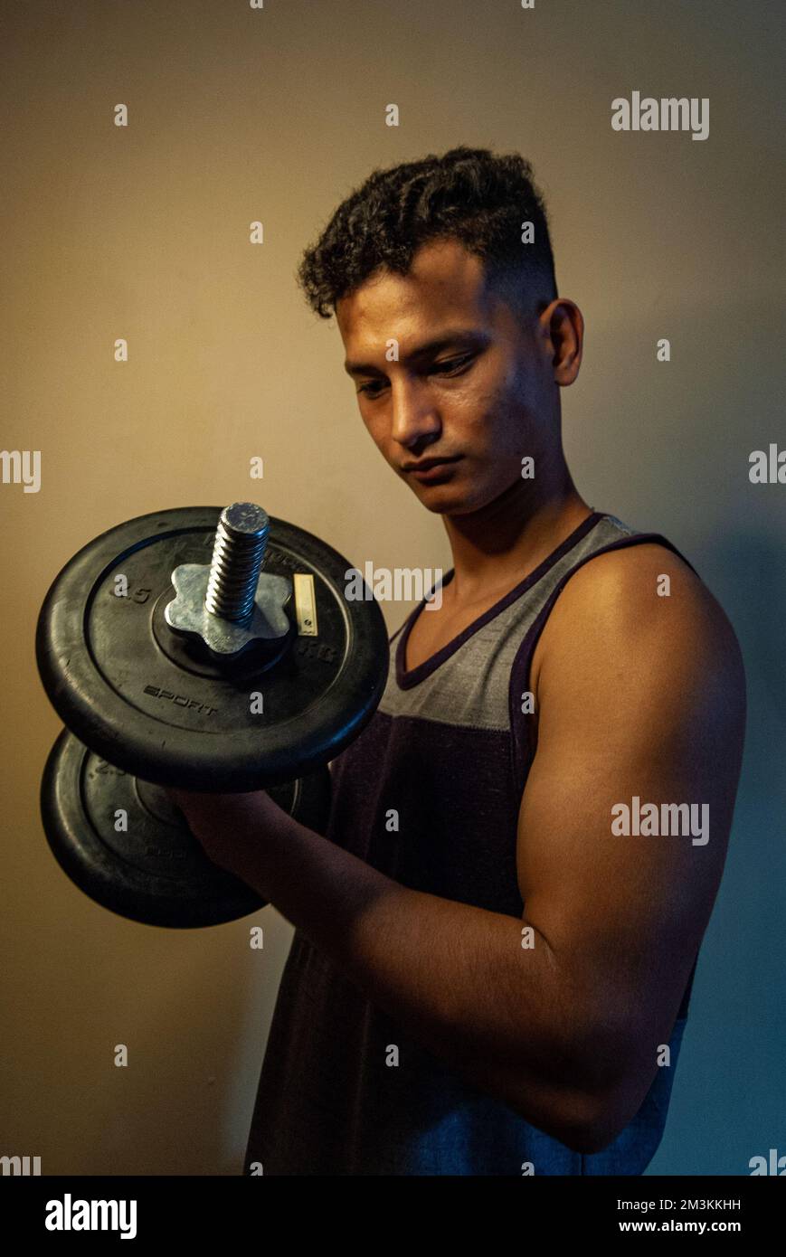 Muscular man lifting a black dumbbell Stock Photo - Alamy