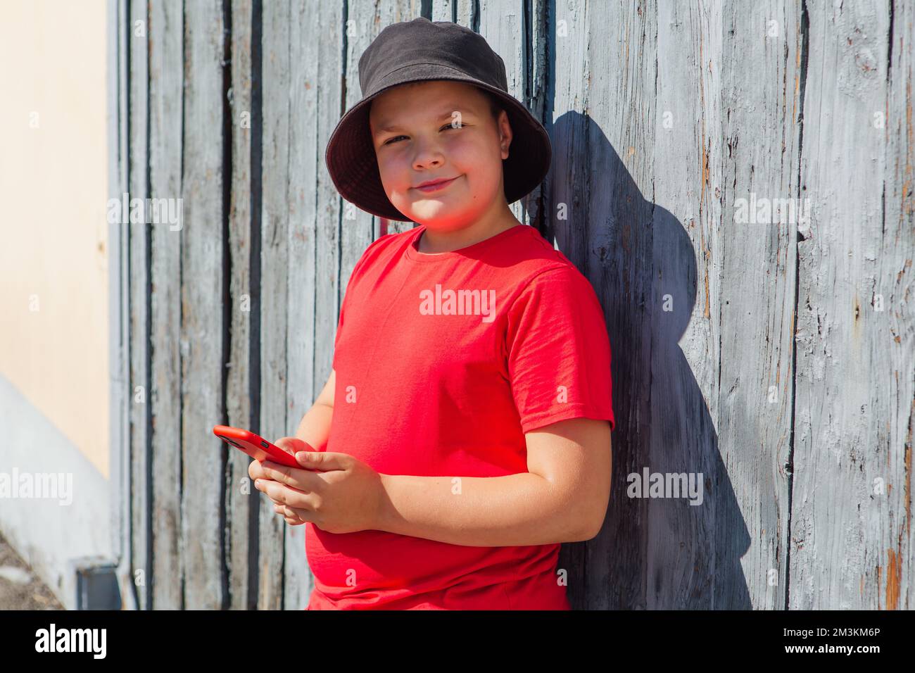Happy chubby ten years old boy with staring at smartphone. Teen using ...