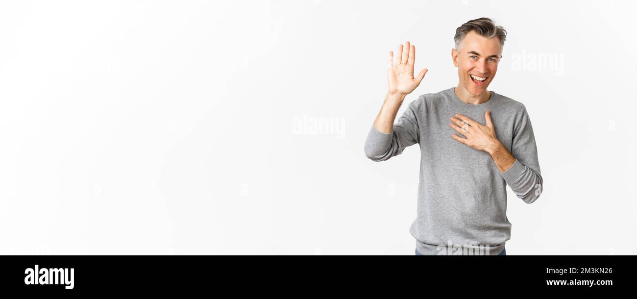 Portrait of handsome middle-aged man making promise, raising one hand ...