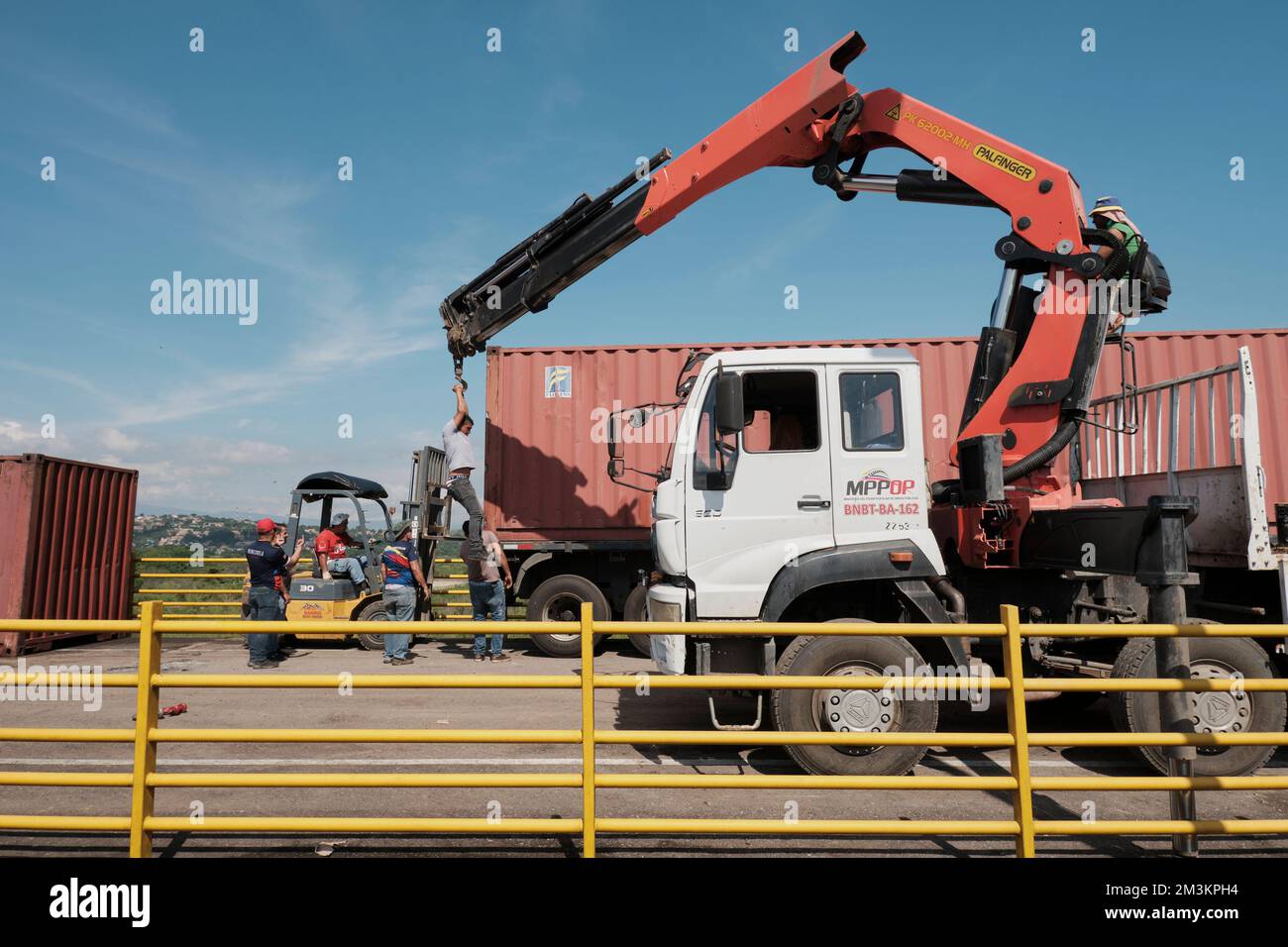 Cucuta, Colombia. 15th Dec, 2022. Venezuelan government employees remove containers that have ...