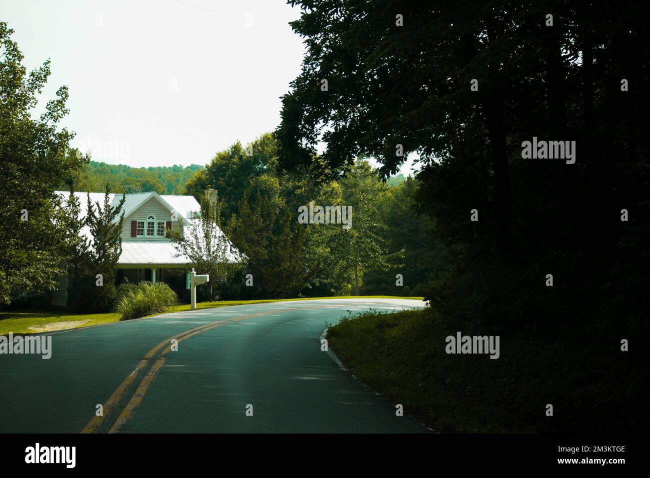 bending road street view house and sky in background Stock Photo - Alamy