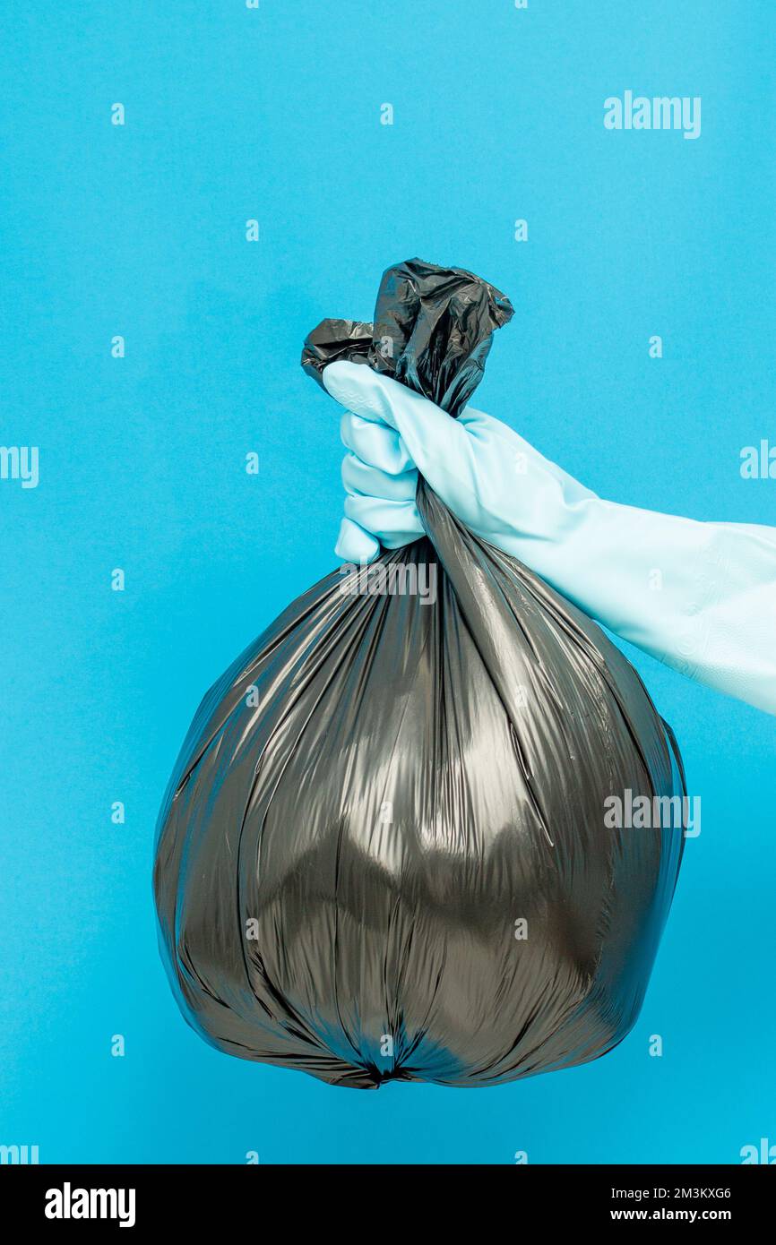 Cleaner concept, Hand in rubber gloves and holding plastic bag with ...