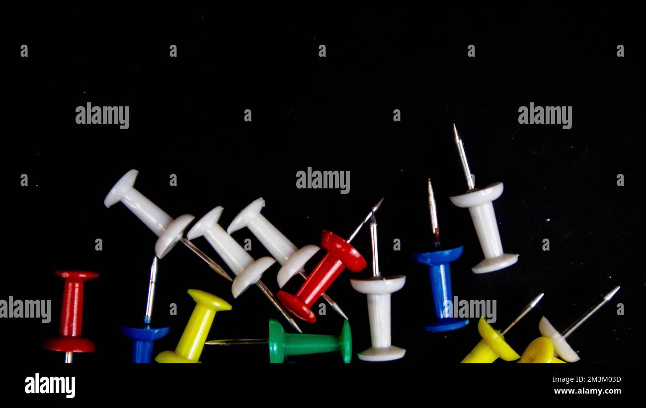 colorful thumbtacks on black background Stock Photo - Alamy