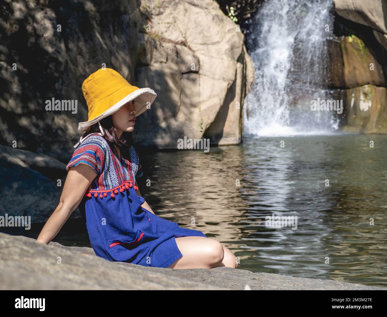 Women wear traditional Thai costumes and yellow hats. Sitting by the ...