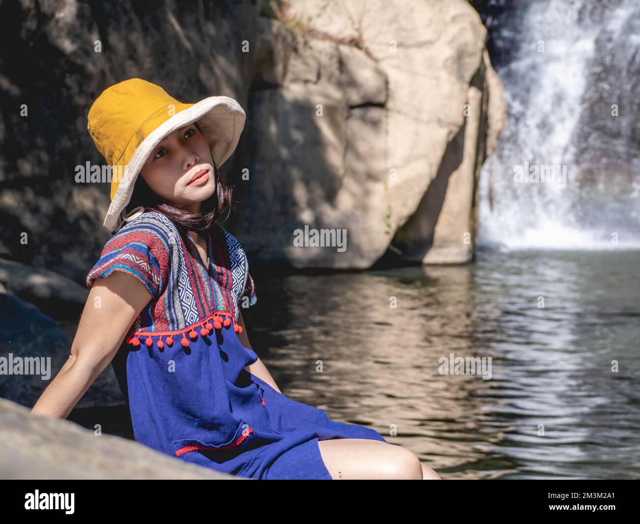 Women wear traditional Thai costumes and yellow hats. Sitting by the ...