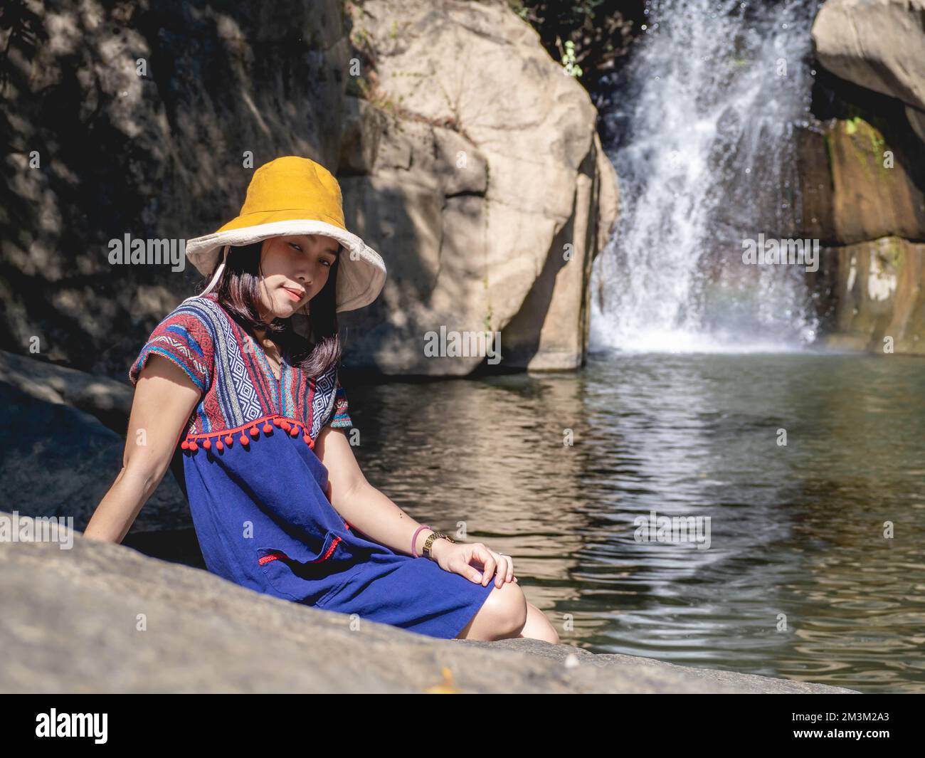 Women wear traditional Thai costumes and yellow hats. Sitting by the ...