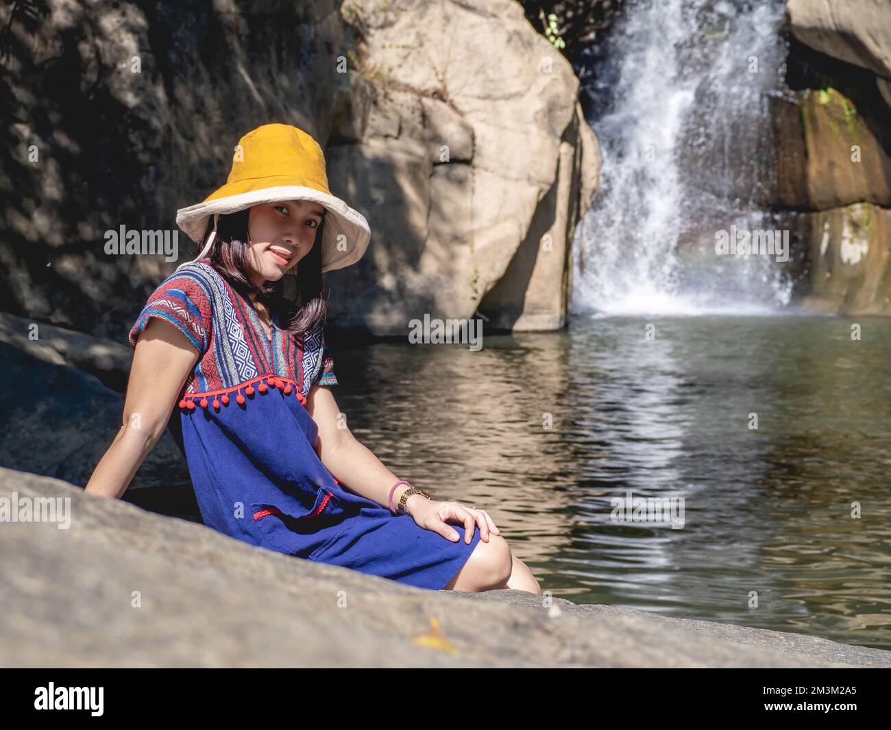Women wear traditional Thai costumes and yellow hats. Sitting by the ...