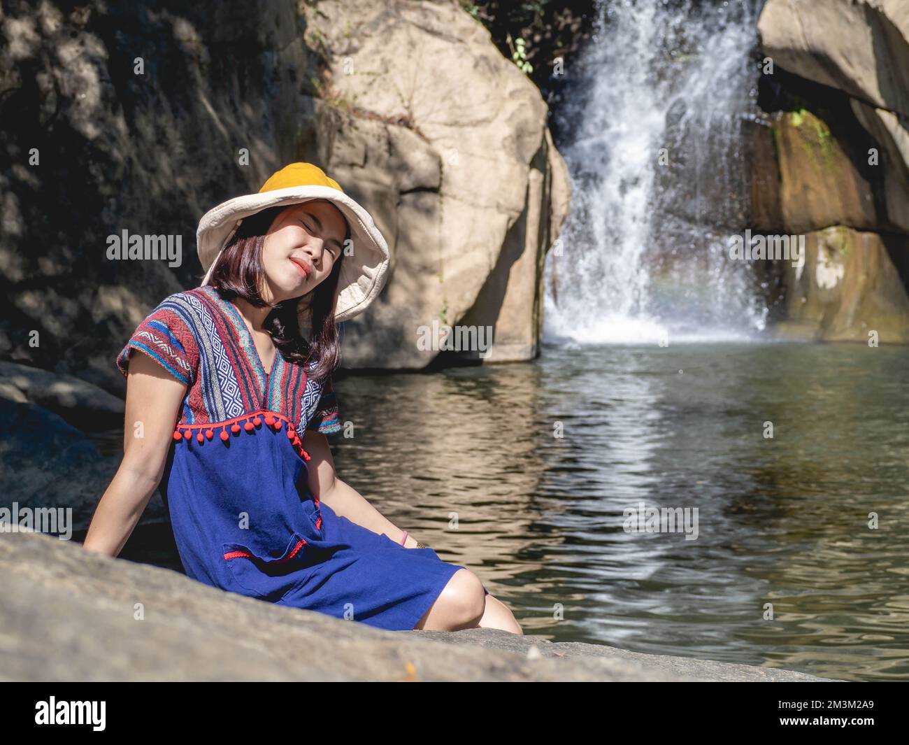 Women wear traditional Thai costumes and yellow hats. Sitting by the ...