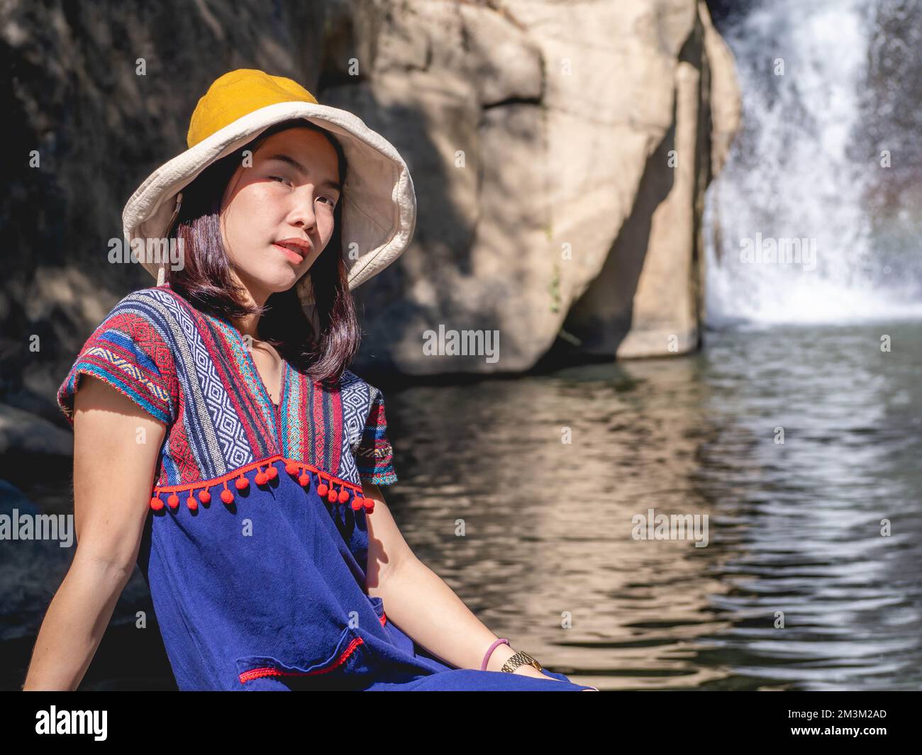 Women wear traditional Thai costumes and yellow hats. Sitting by the ...