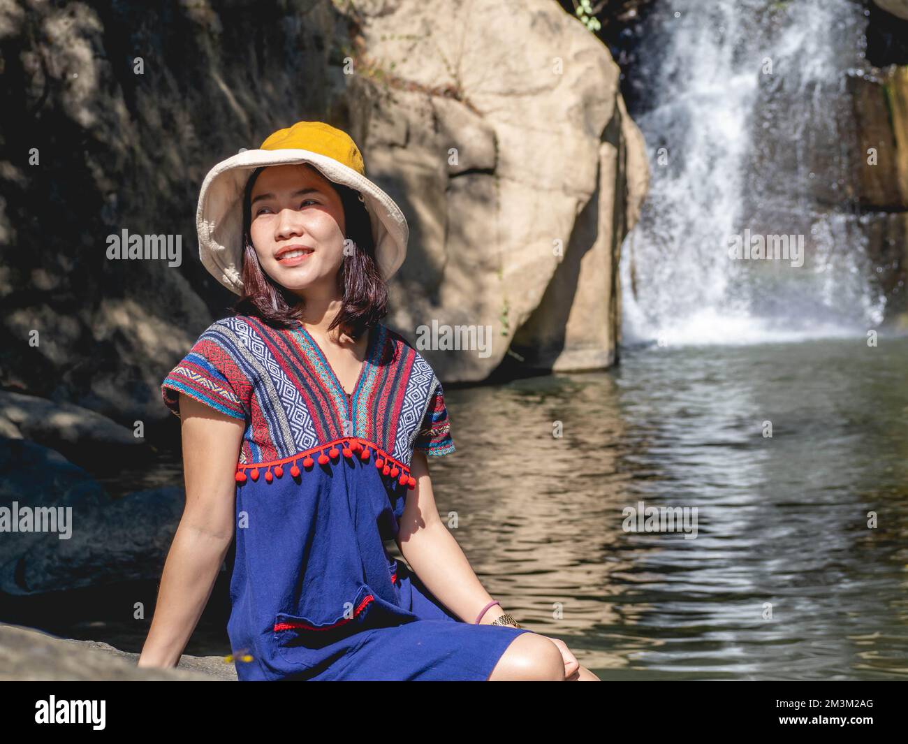 Women wear traditional Thai costumes and yellow hats. Sitting by the ...