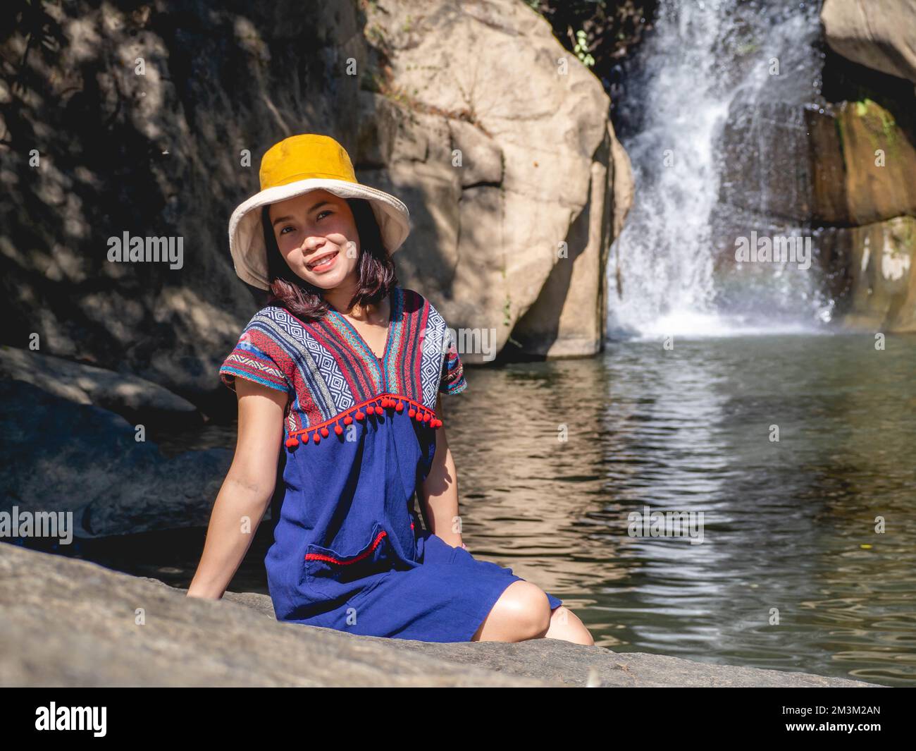 Women wear traditional Thai costumes and yellow hats. Sitting by the ...
