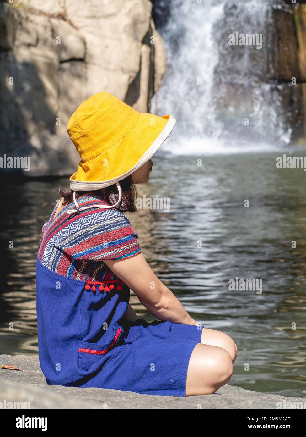 Women wear traditional Thai costumes and yellow hats. Sitting by the ...