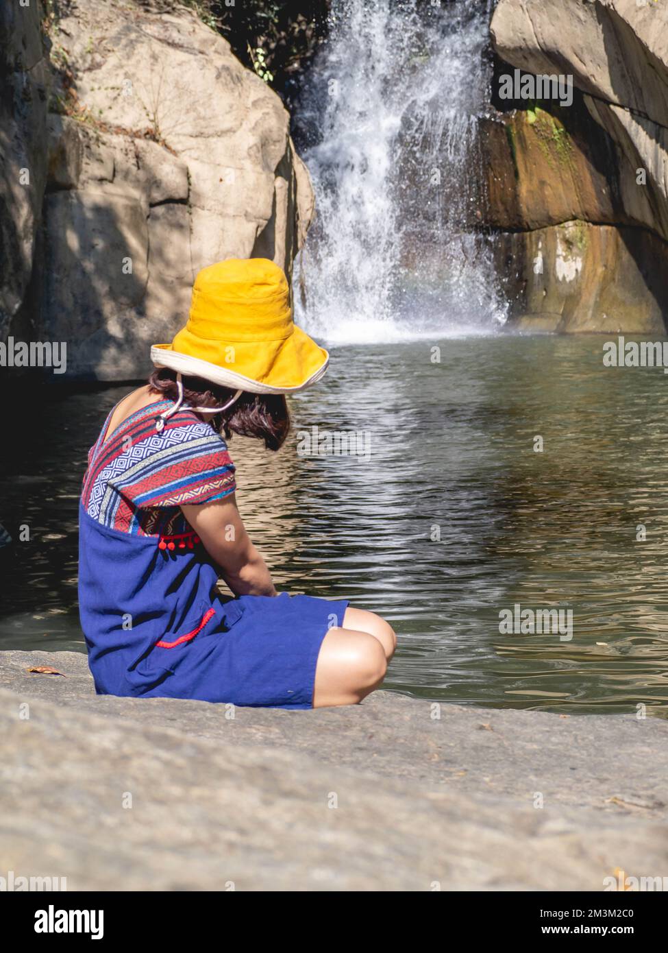Women wear traditional Thai costumes and yellow hats. Sitting by the ...