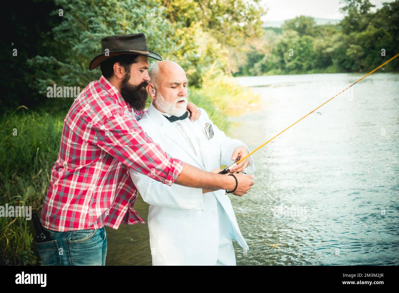 Portrait of cheerful senior man fishing. Grandfather and son fishermans ...