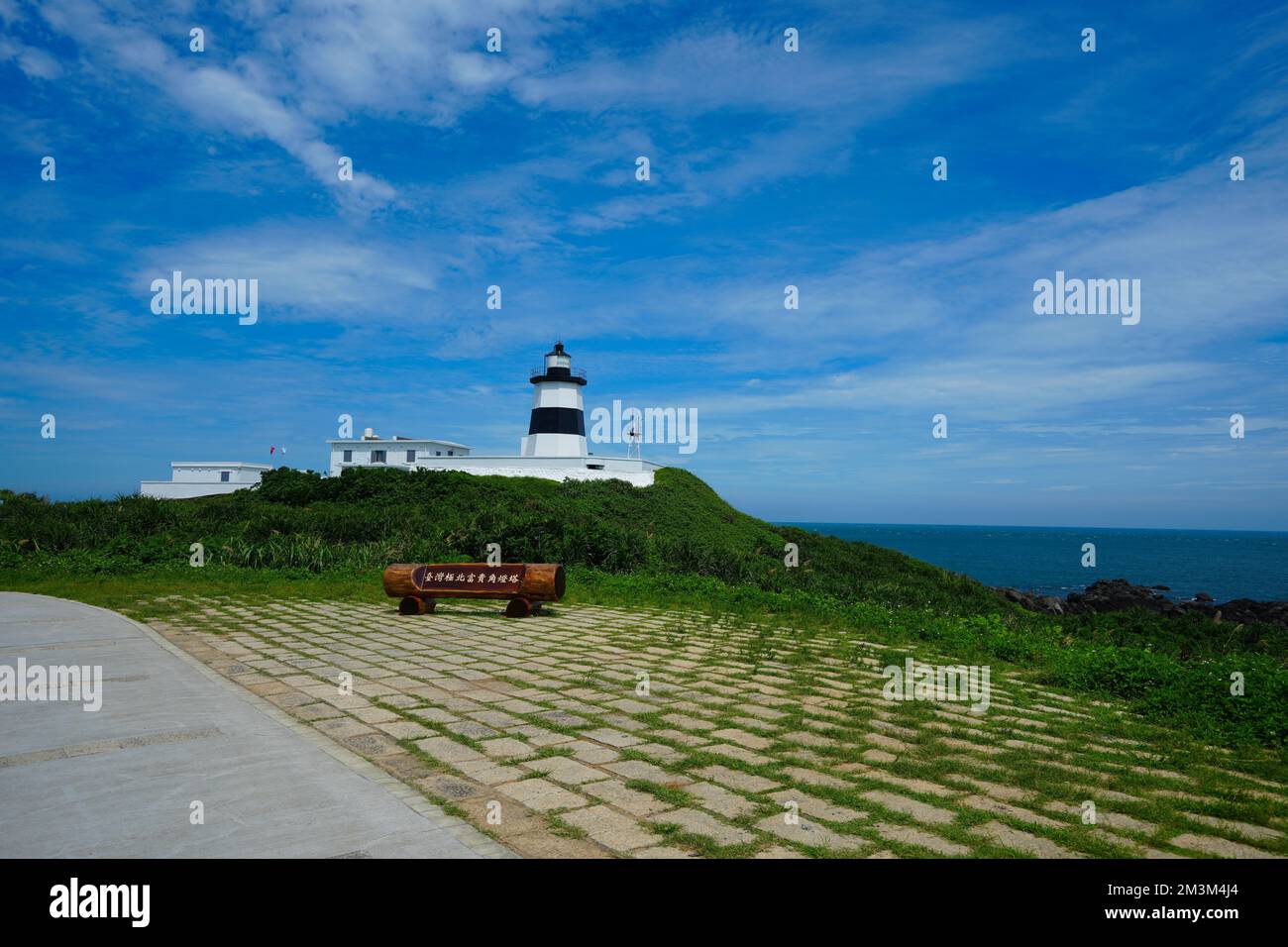 Fugui Cape Lighthouse under the blue sky and white clouds. Black and ...