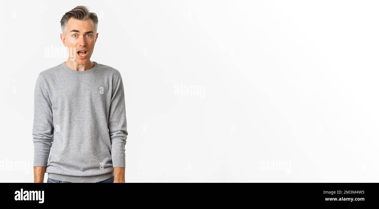 Portrait of handsome middle-aged man with gray hair, looking confused ...