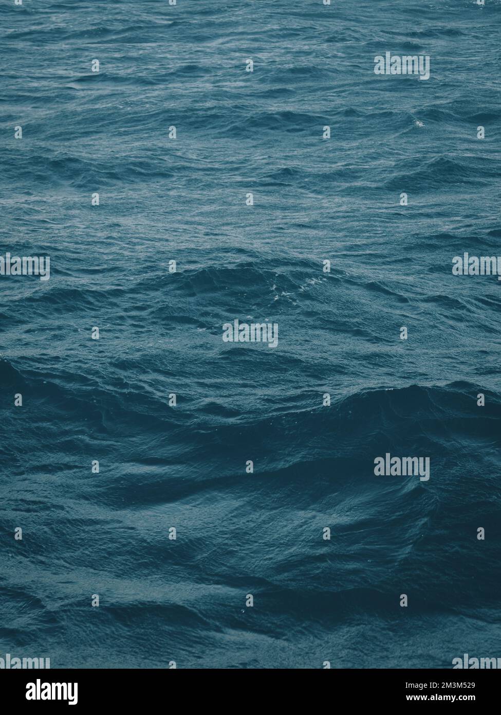 Dark blue-green color of water surface with waves in middle of endless ...