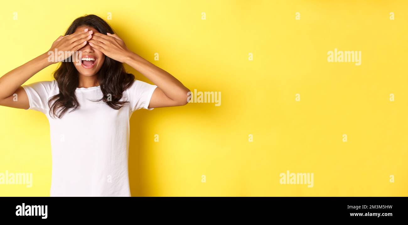 Image of excited african-american girl waiting for surprise, smiling ...