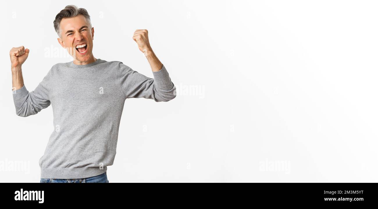 Image of successful middle-aged man triumphing, shouting for joy ...