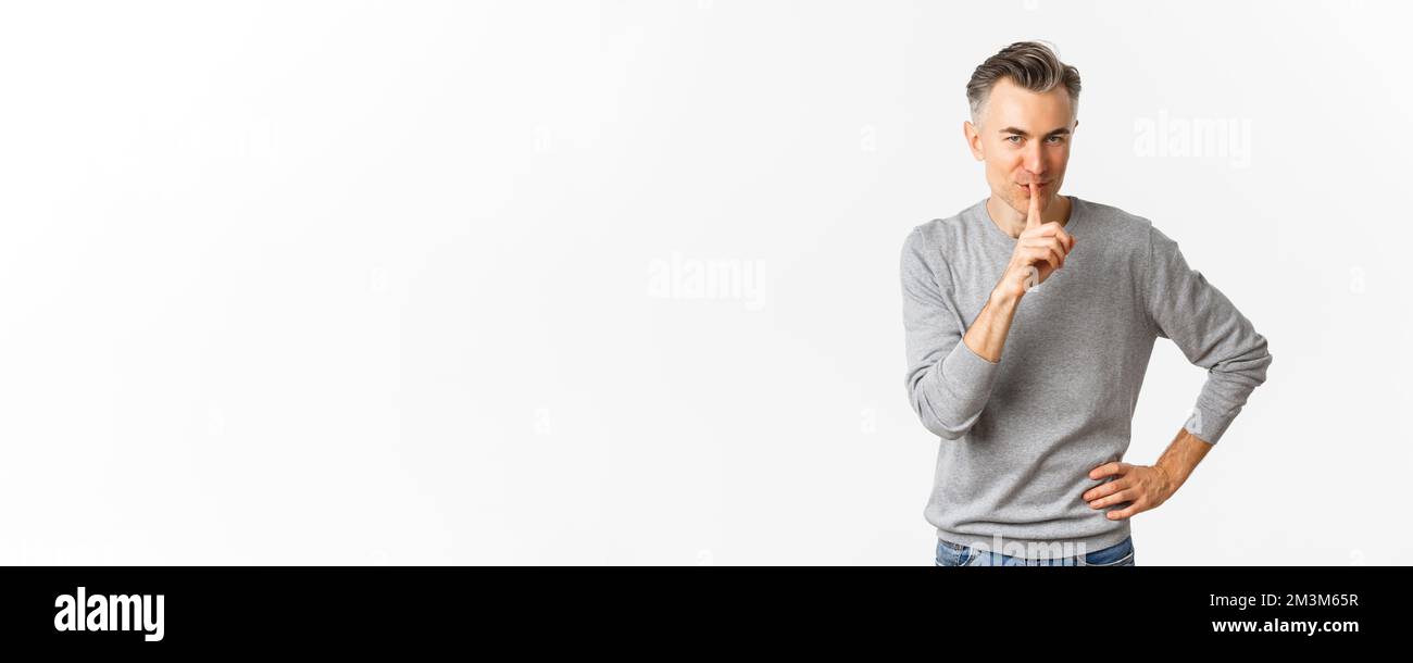 Portrait of cunning handsome man with gray hair, hushing and smiling ...
