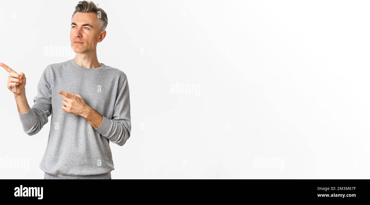 Image of thoughful handsome man, making decision, pointing and looking ...