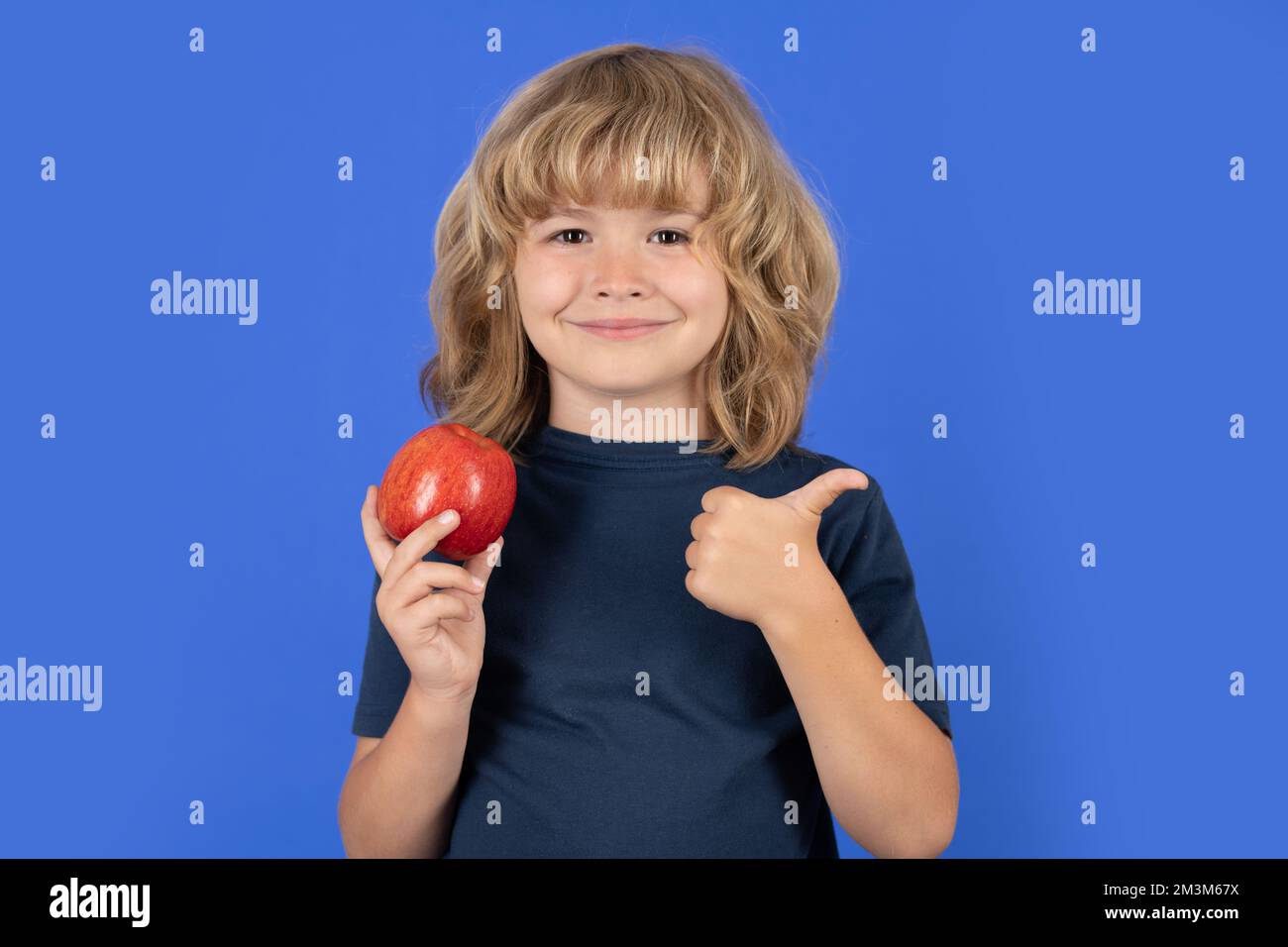 Healthy eating. Smiling child with thumbs up hold apple. Portrait of of ...