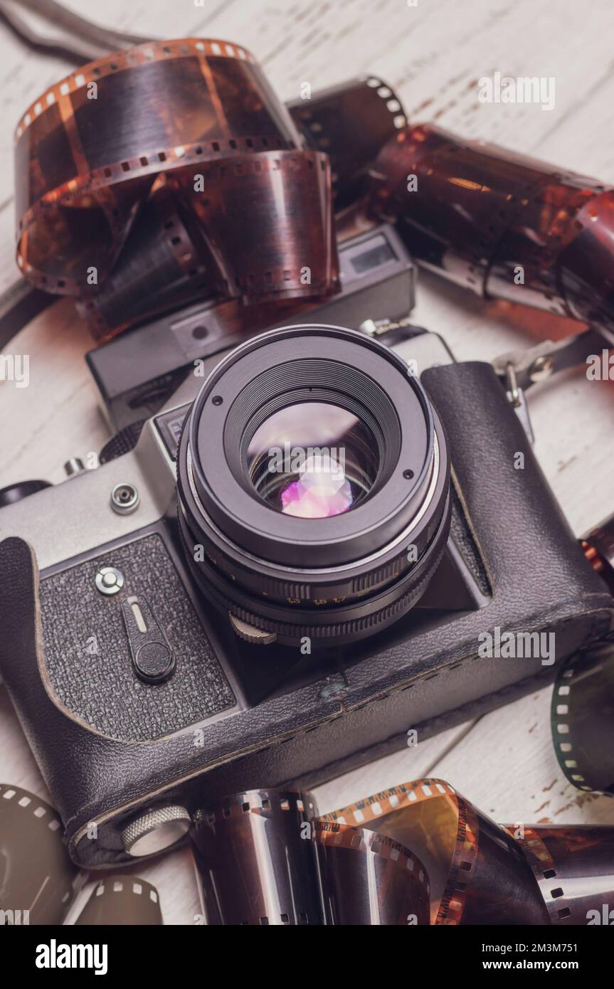 Old retro camera with lens flare. Rolled up film next to it Stock Photo ...