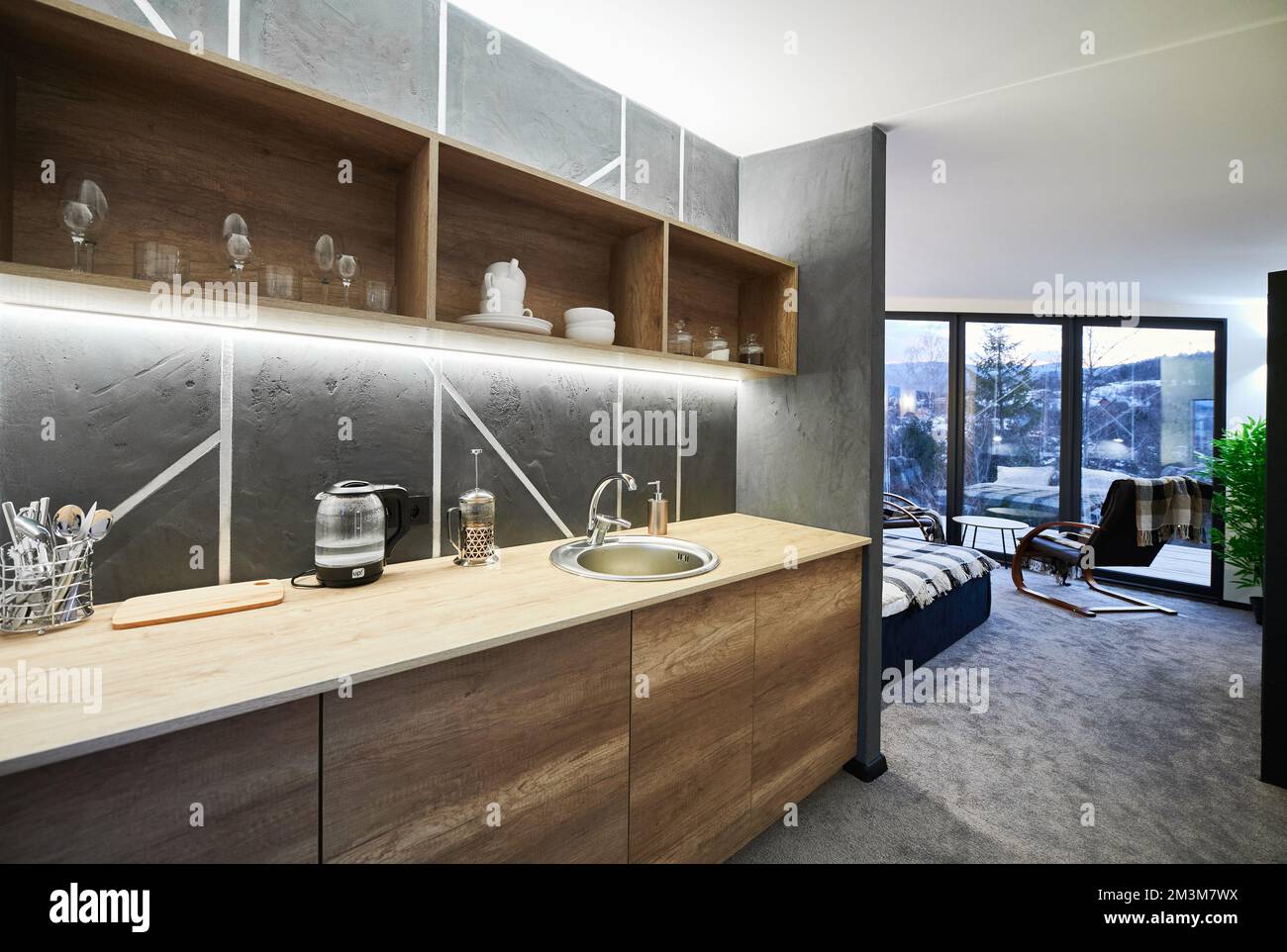 Modern interior of kitchen area in front of grey wall inside. Side view ...