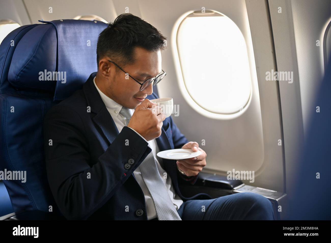 Successful Asian businessman or male CEO sits at the window seat on his ...