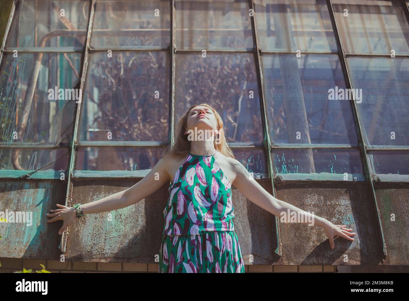 Young woman with closed eyes posing against tall windows scenic photography Stock Photo - Alamy
