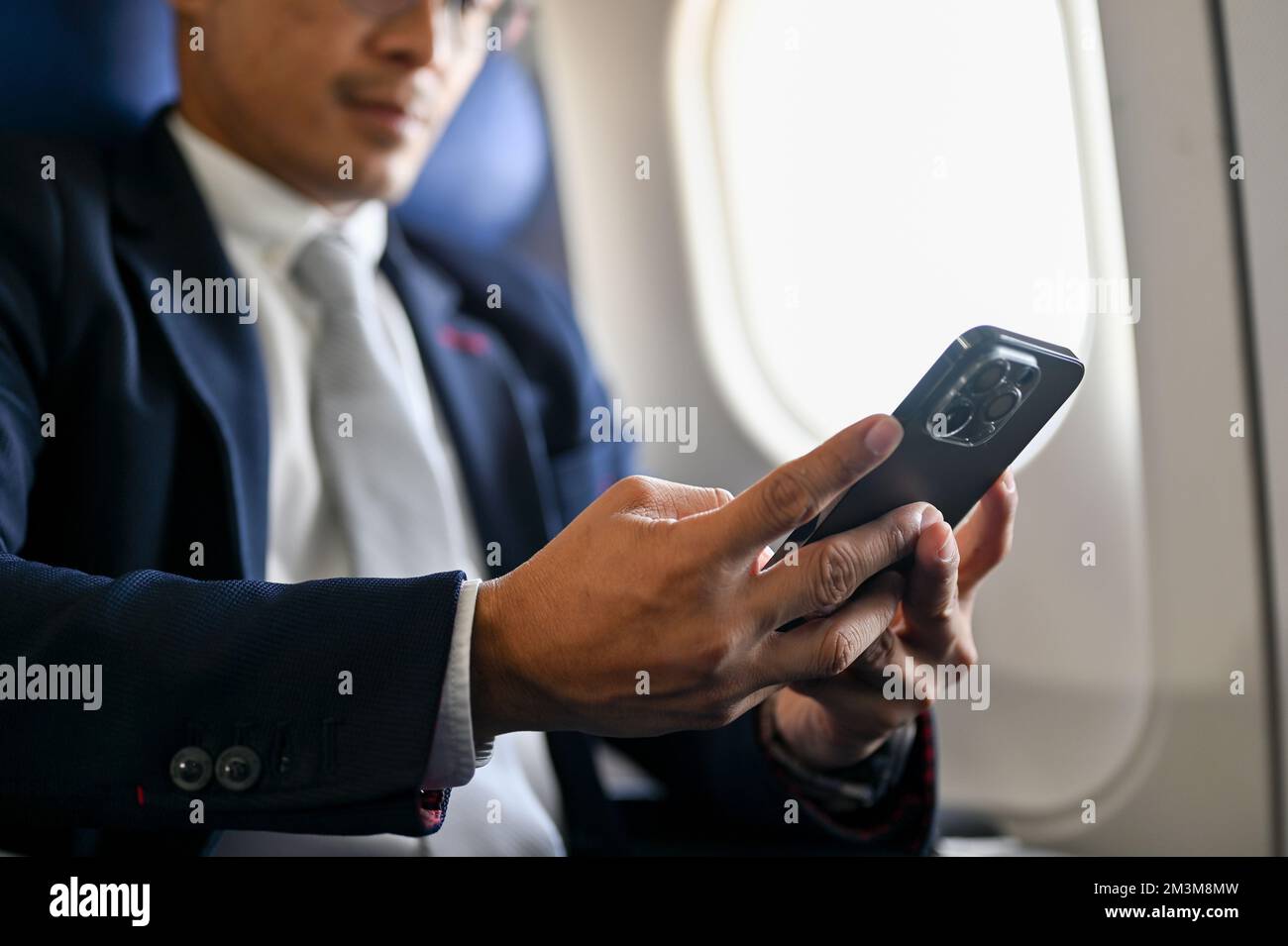 Professional Asian businessman in formal suit sits in business class ...