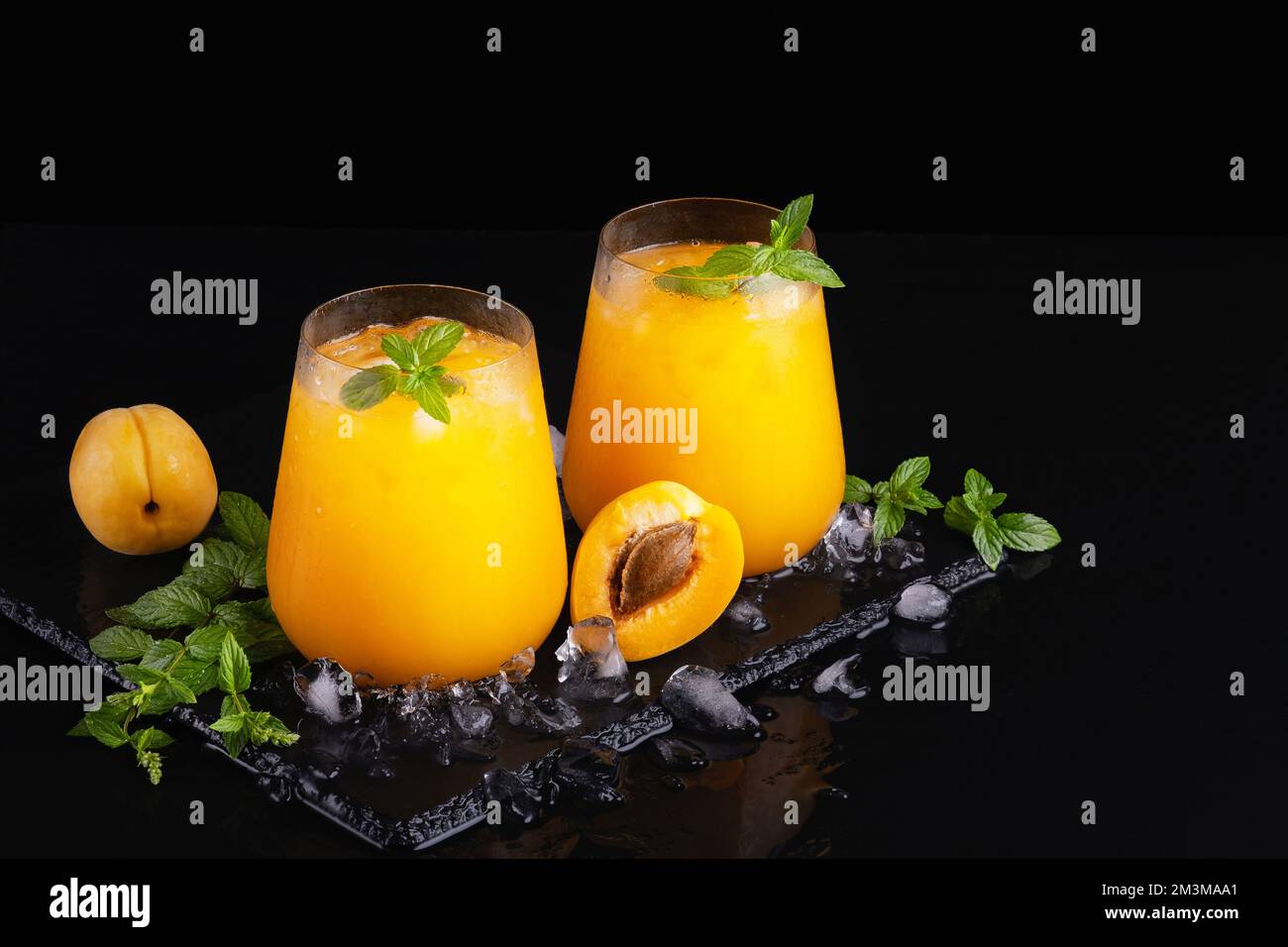 Fresh sweet apricot juice and mint on a black background Stock Photo ...