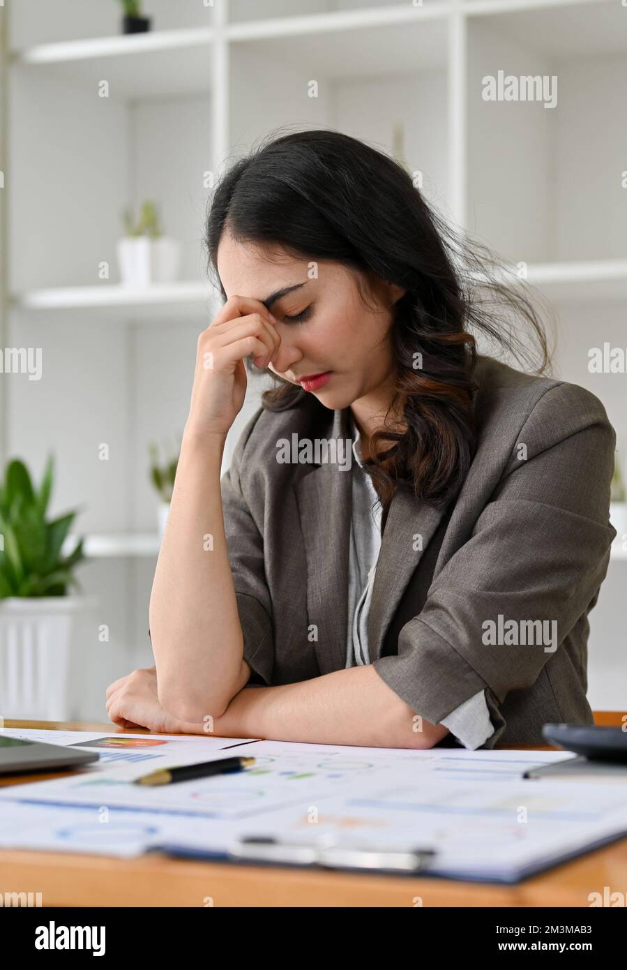 Portrait of a stressed millennial Asian businesswoman worried about her ...