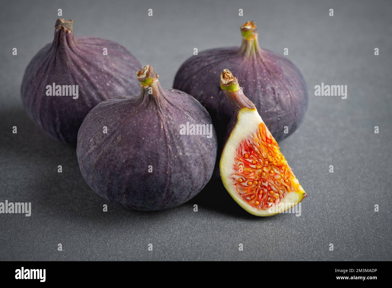 Fresh figs on grey background. Beautiful blue violet fruit close up ...
