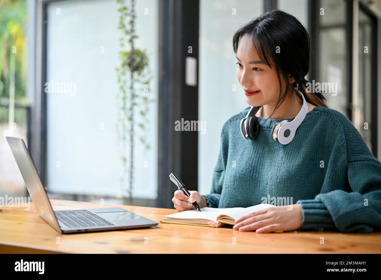Smart and pretty young Asian female college student concentrating on ...