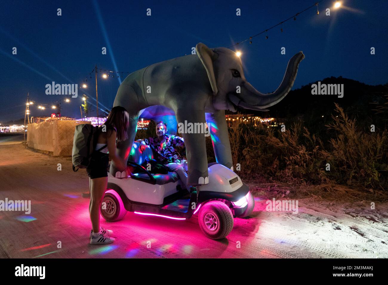 Pattaya, Thailand. December 16 2022. A festival goer catches a ride in ...