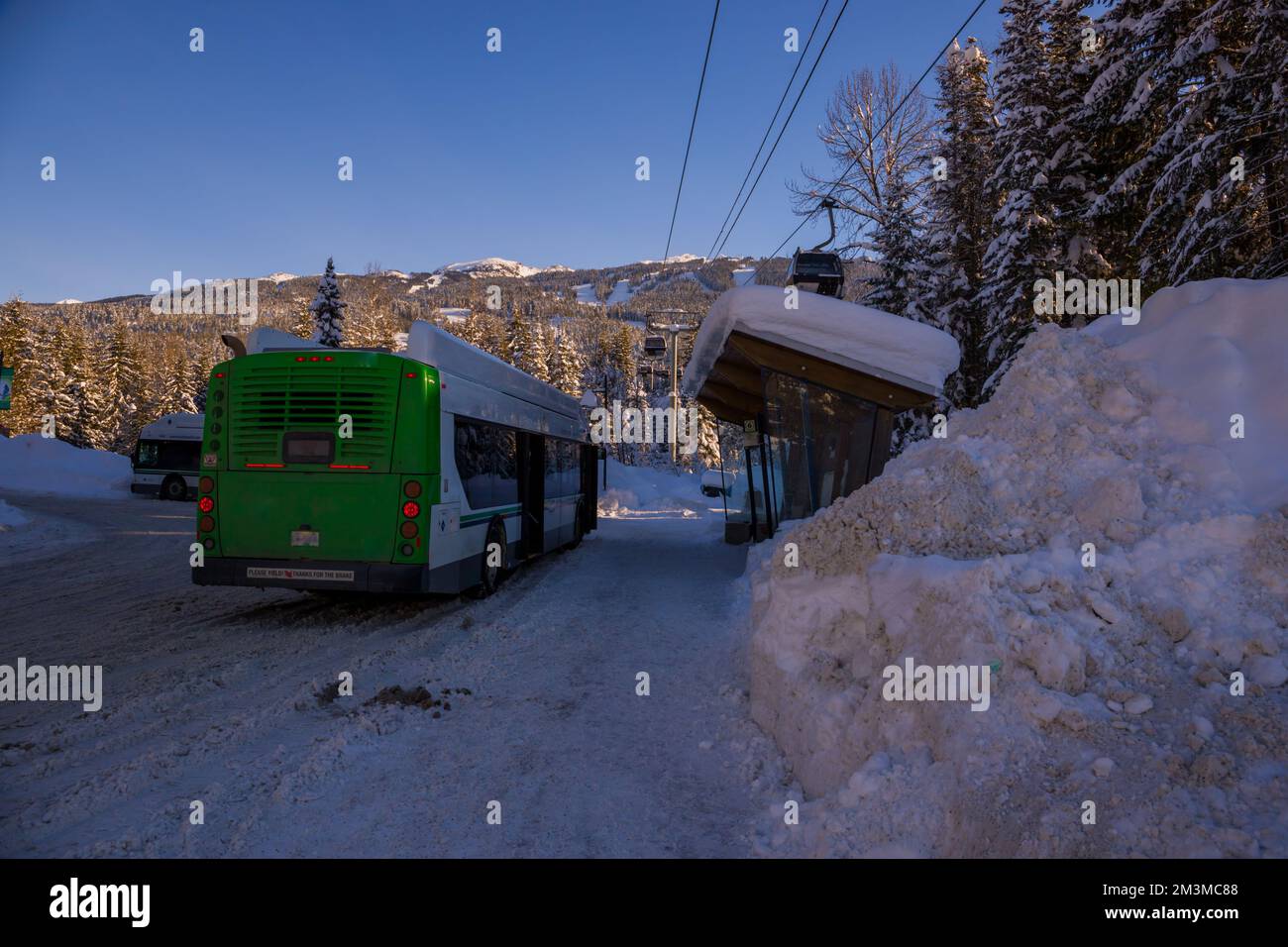 Winter village in the mountains, sunny day. Transportation - the bus ...
